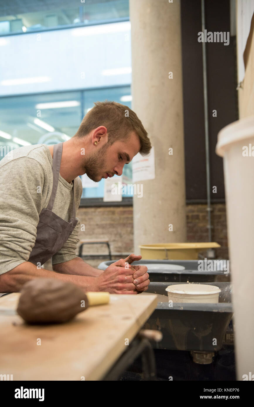 Man in art studio using pottery wheel Stock Photo - Alamy