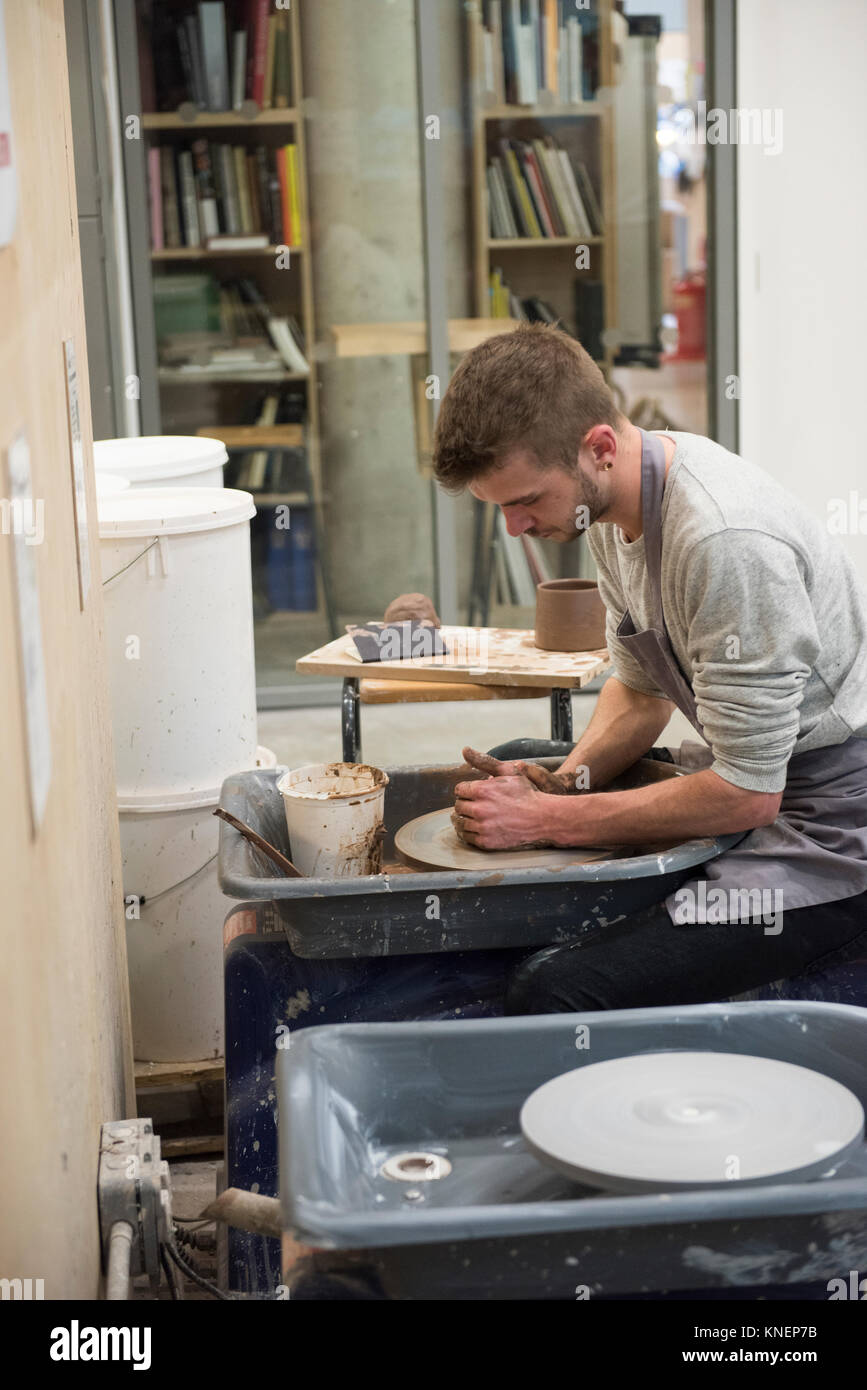 Man in art studio using pottery wheel Stock Photo - Alamy