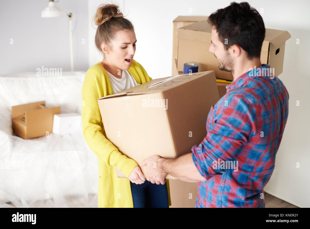 Young couple moving home, carrying heavy cardboard box Stock Photo - Alamy
