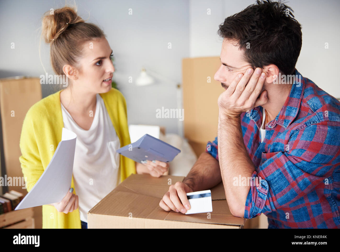 Young couple at home, surrounded by cardboard boxes, working out ...