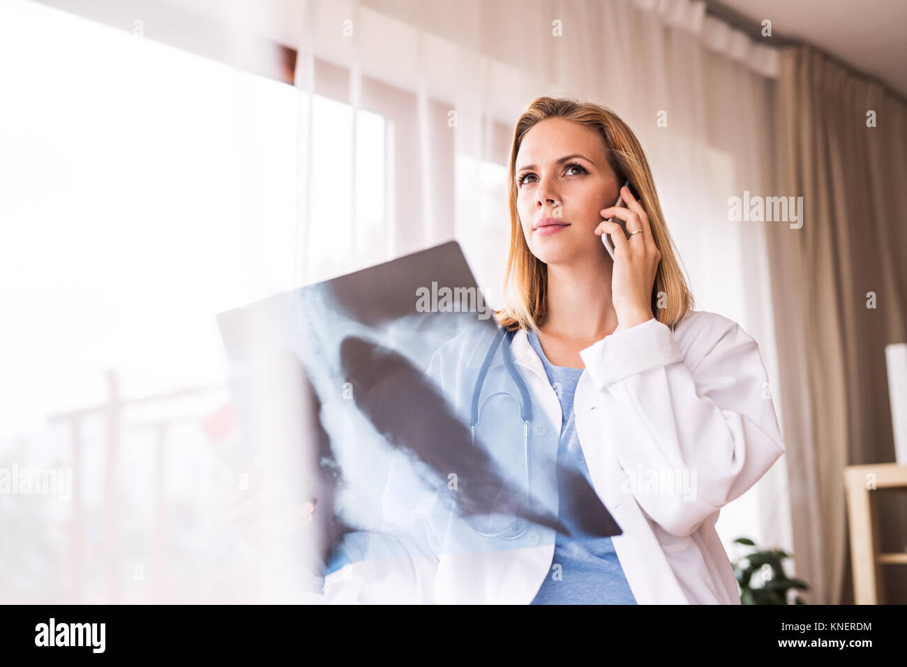 Female doctor with smartphone and x-ray Stock Photo - Alamy