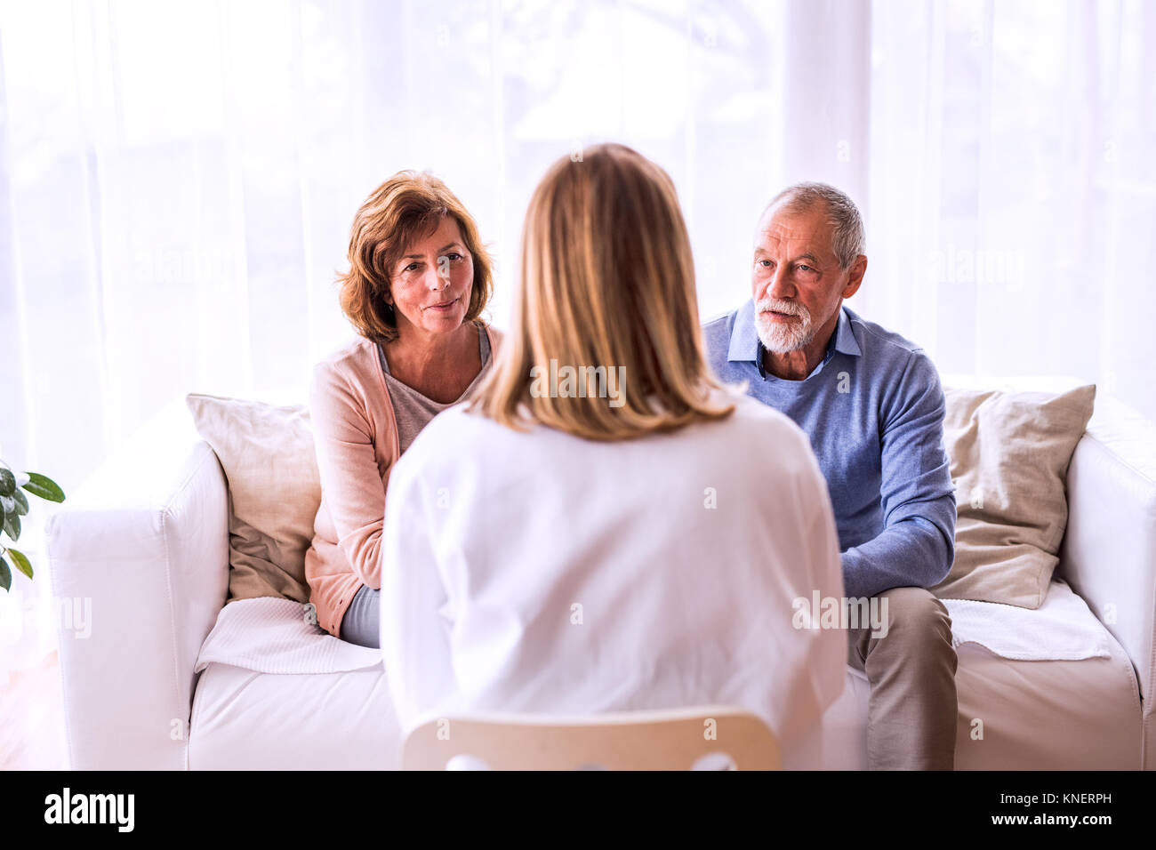 Female doctor talking to a senior couple Stock Photo - Alamy