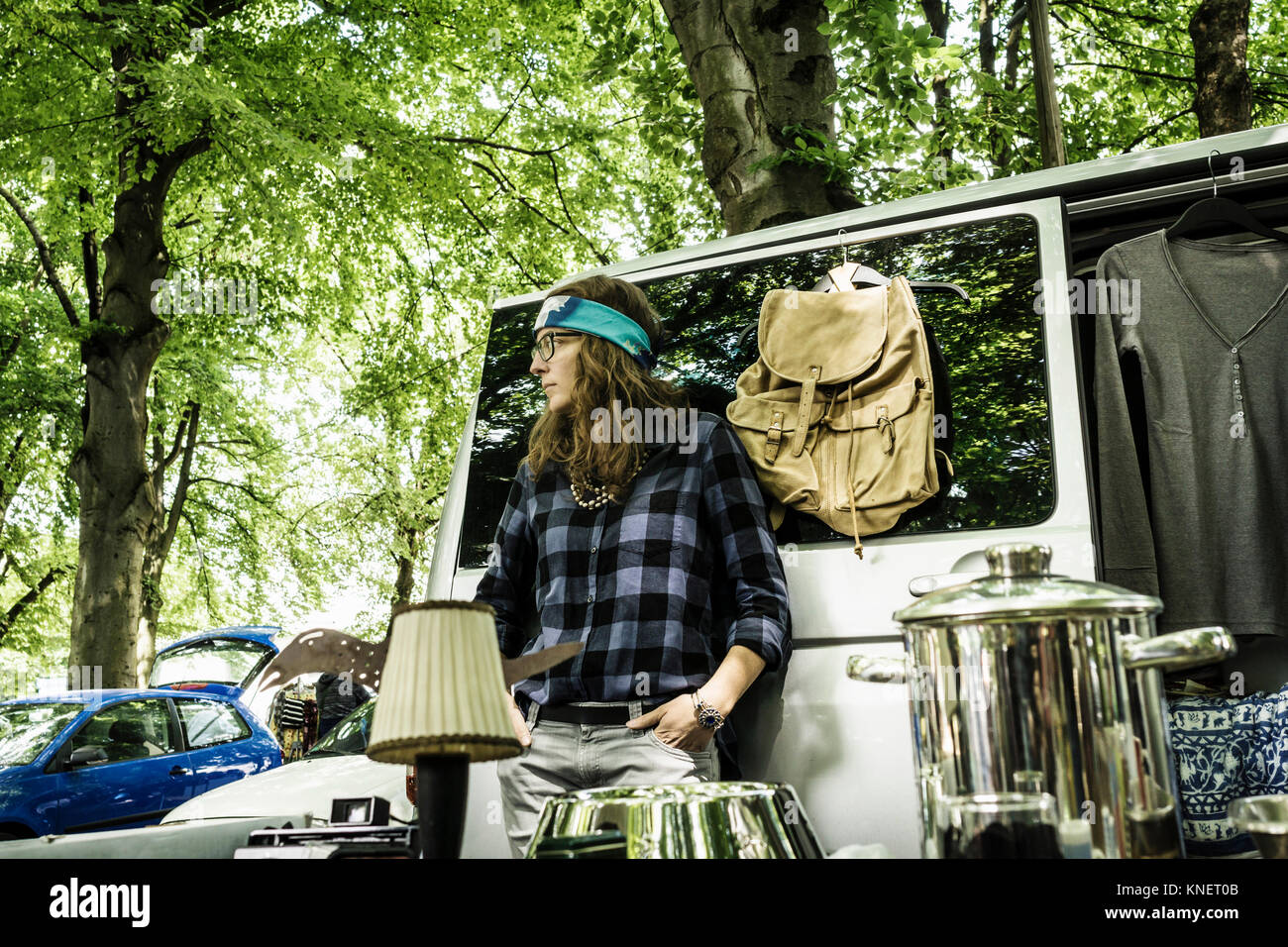Female stall holder leaning against camper van at second hand stall at ...