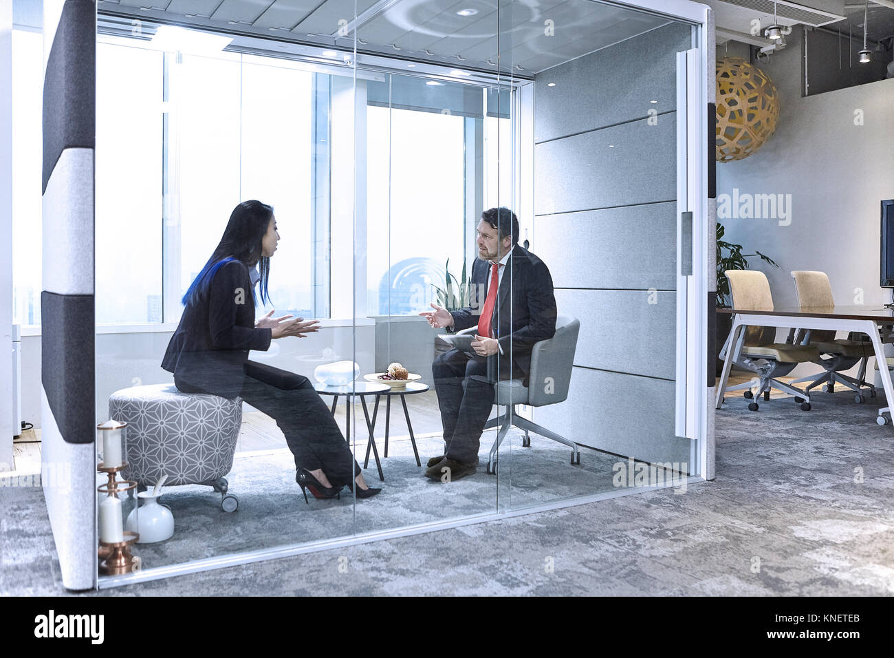 Colleagues having meeting in glass pod in office Stock Photo - Alamy