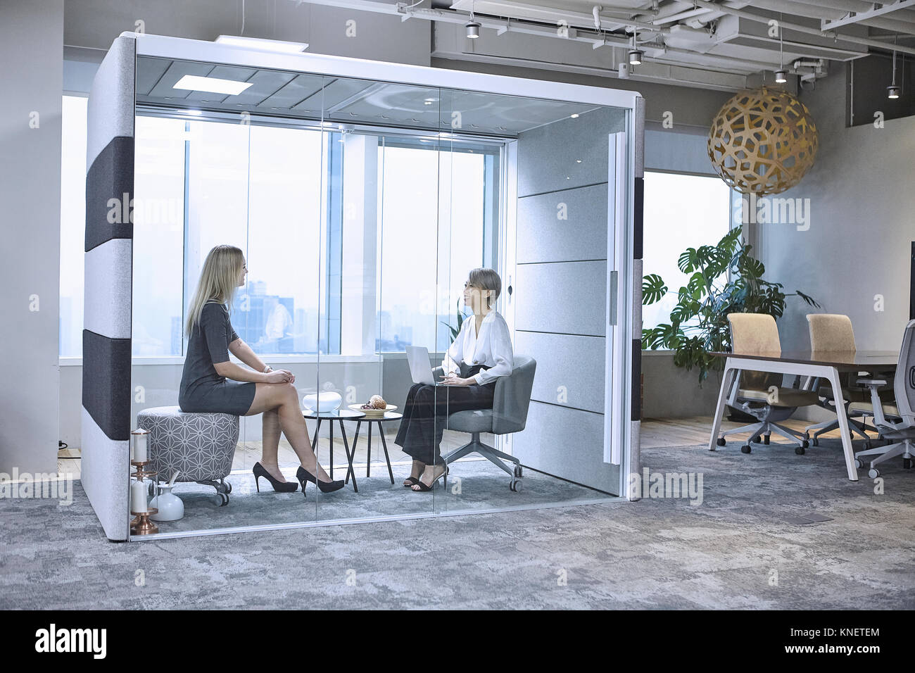 Colleagues having meeting in glass pod in office Stock Photo - Alamy