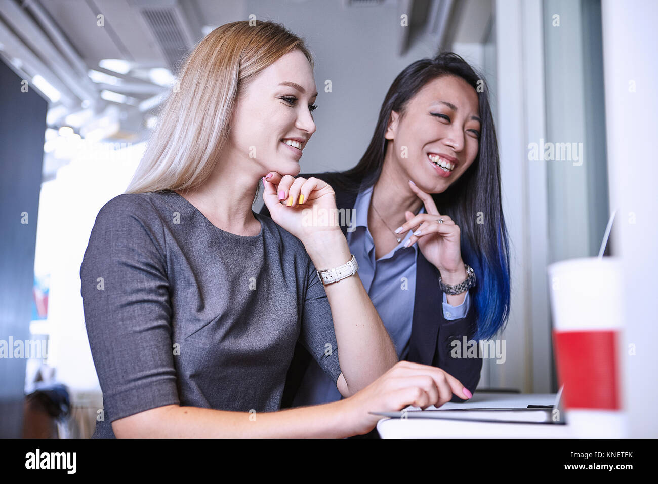 Colleagues using laptop smiling Stock Photo - Alamy