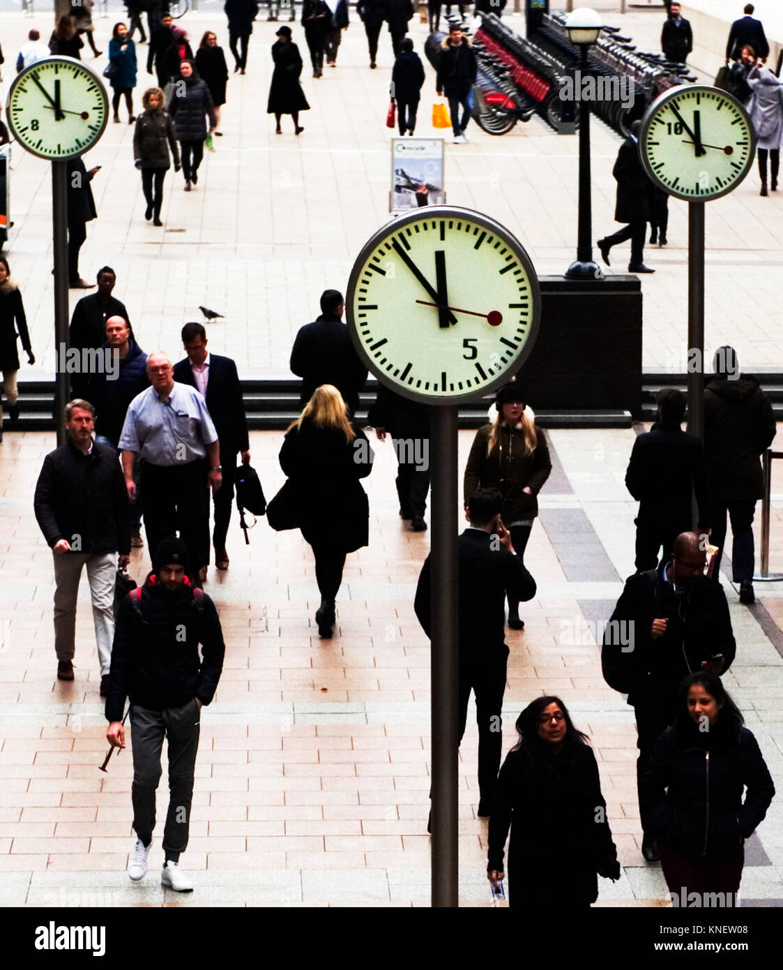 Pedestrians walk past decorative clocks in the Canary Wharf financial ...