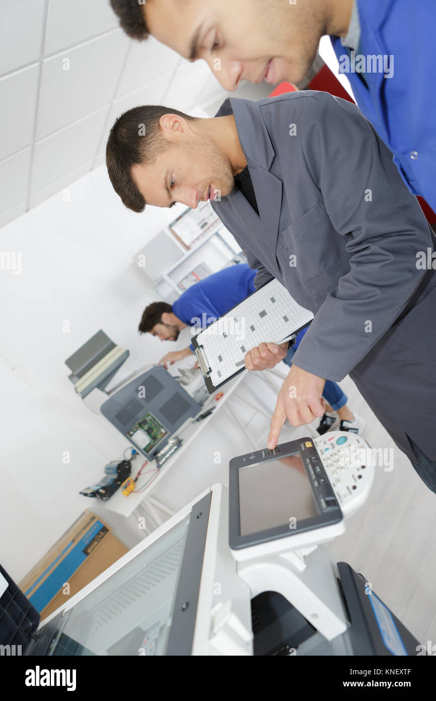 apprentice checking photocopier Stock Photo - Alamy