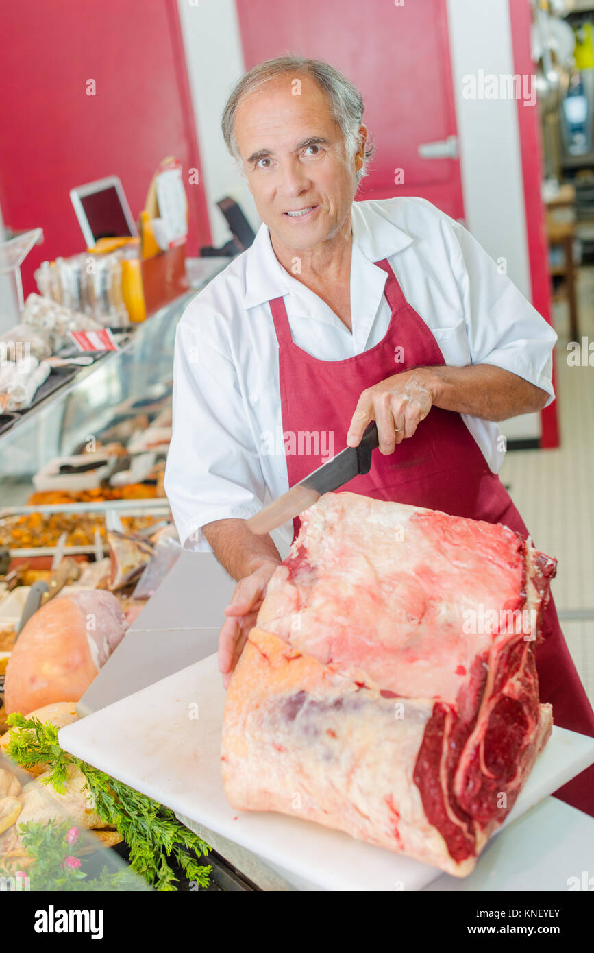 butcher in the process of cutting a meat Stock Photo - Alamy