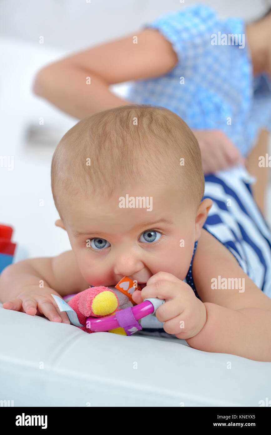 small newborn baby schewing on a plastic rattle Stock Photo - Alamy