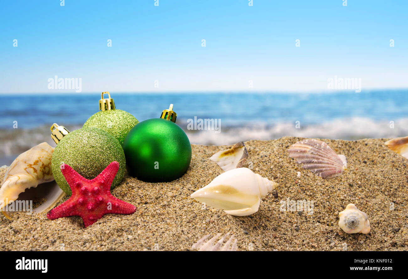 Christmas balls and shells on sand with summer sea background Stock ...