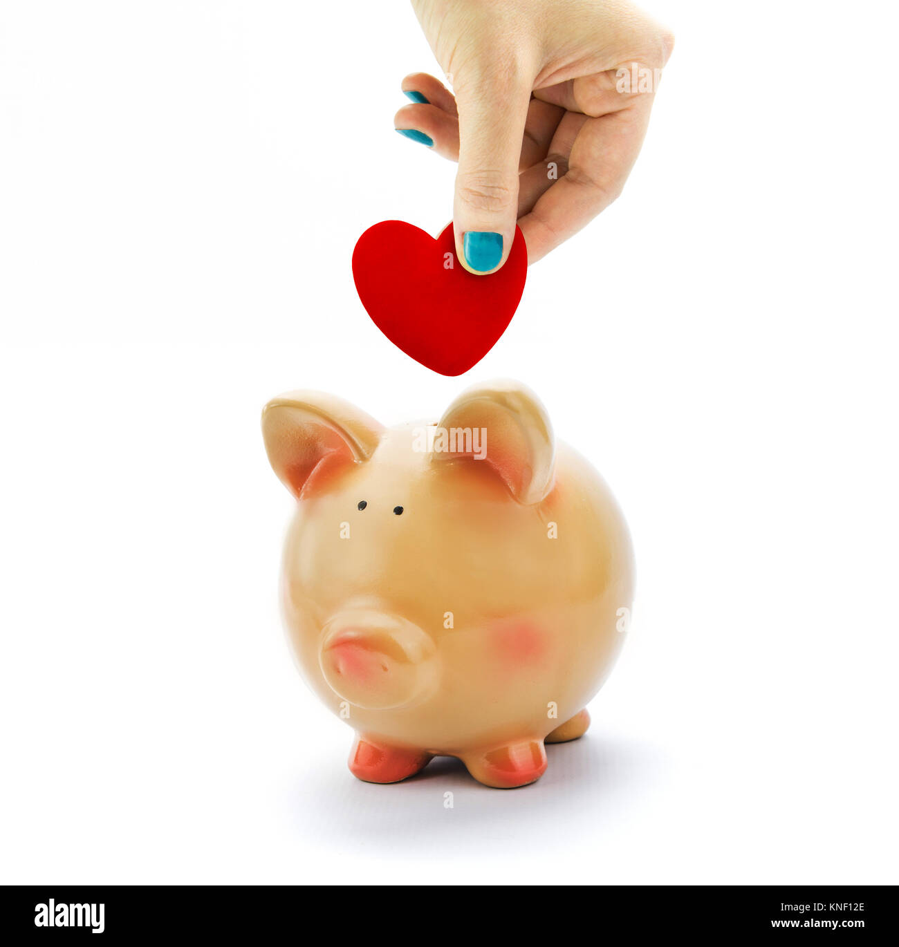 Hand deposit red heart in piggy bank isolated Stock Photo - Alamy