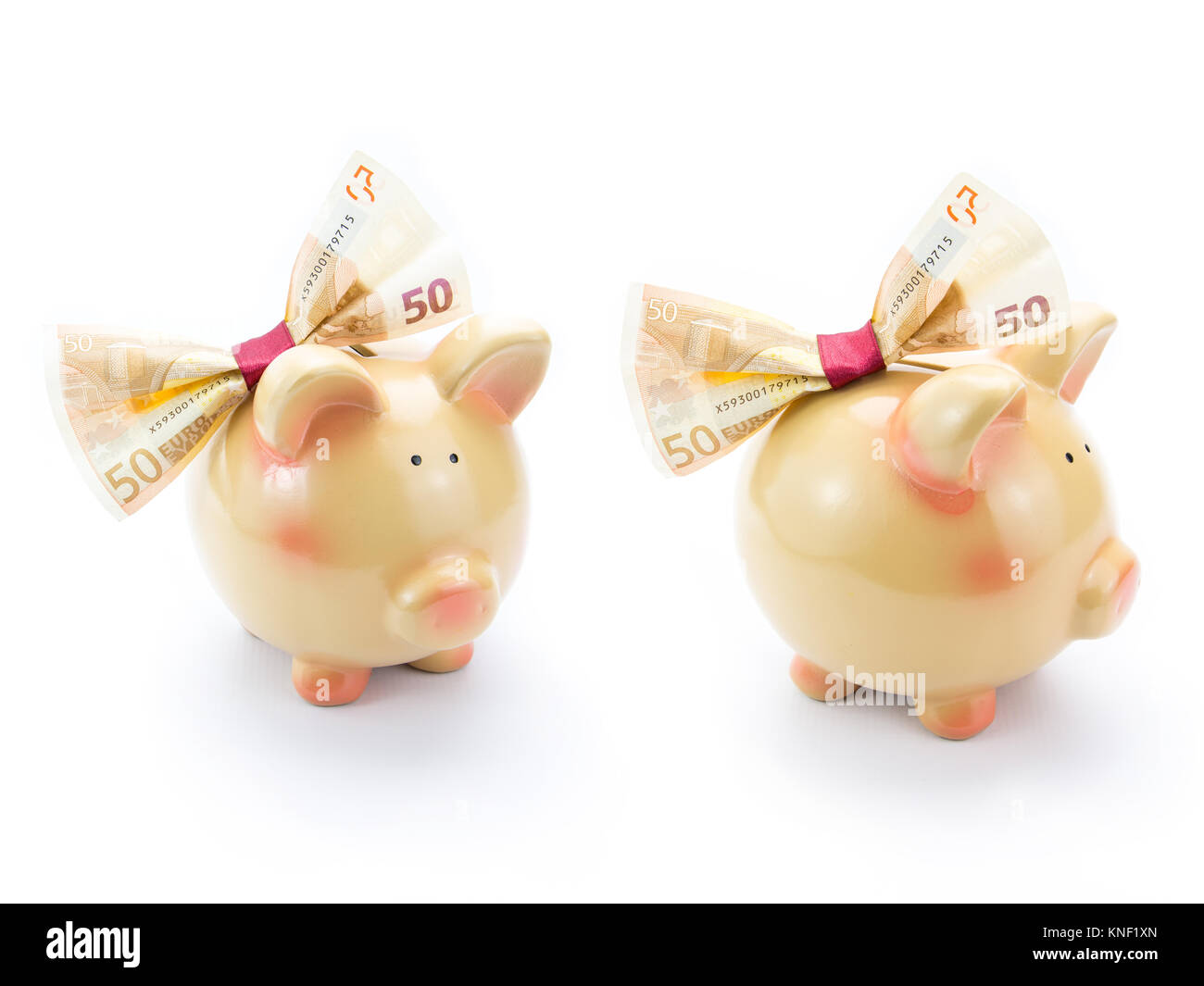 Two cute piggy banks with a banknote bow isolated Stock Photo - Alamy