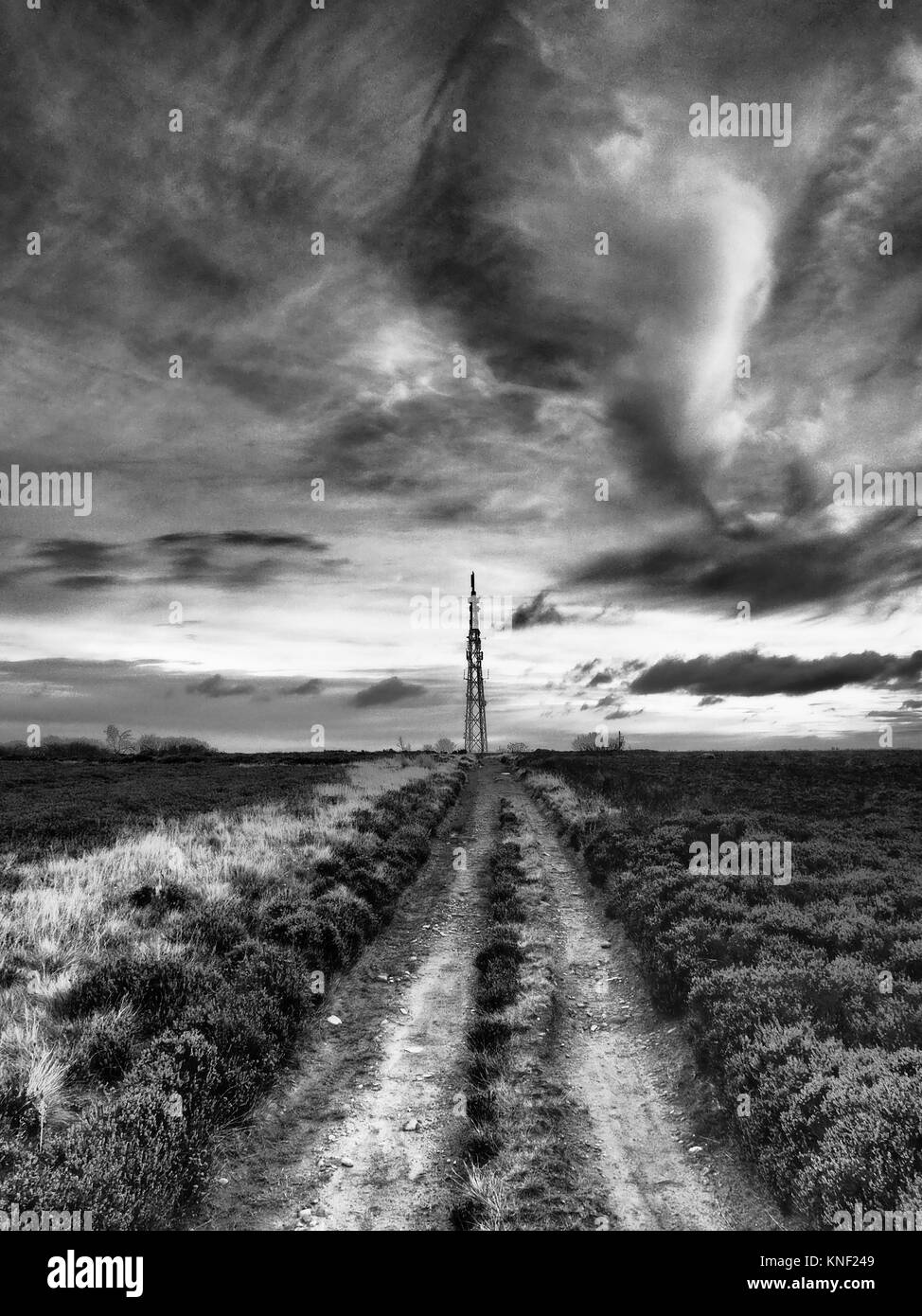 Transmitter mast on moors under brooding sky shot in black and white ...