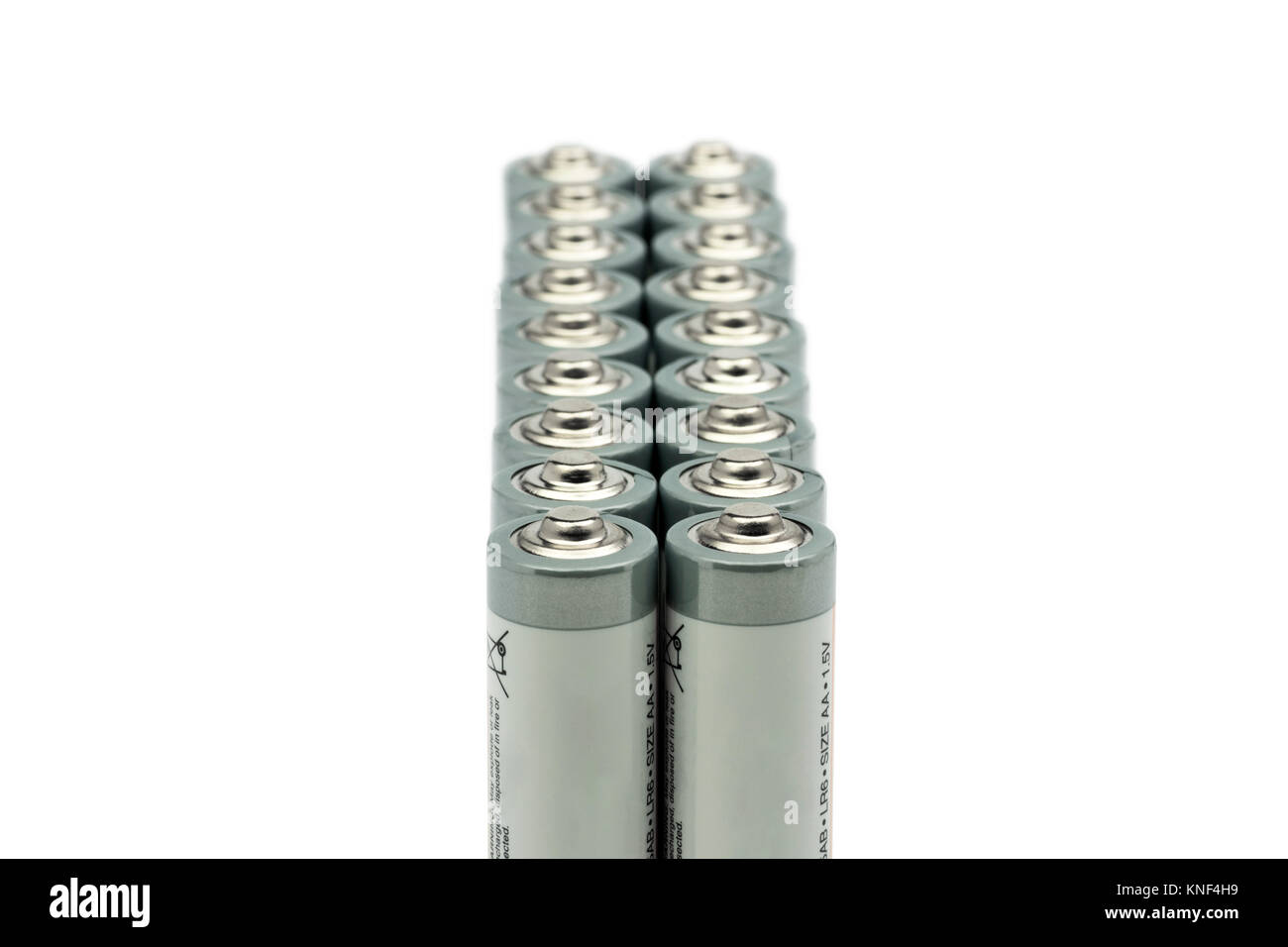 Two series of standing AA batteries, isolated on white background, with ...
