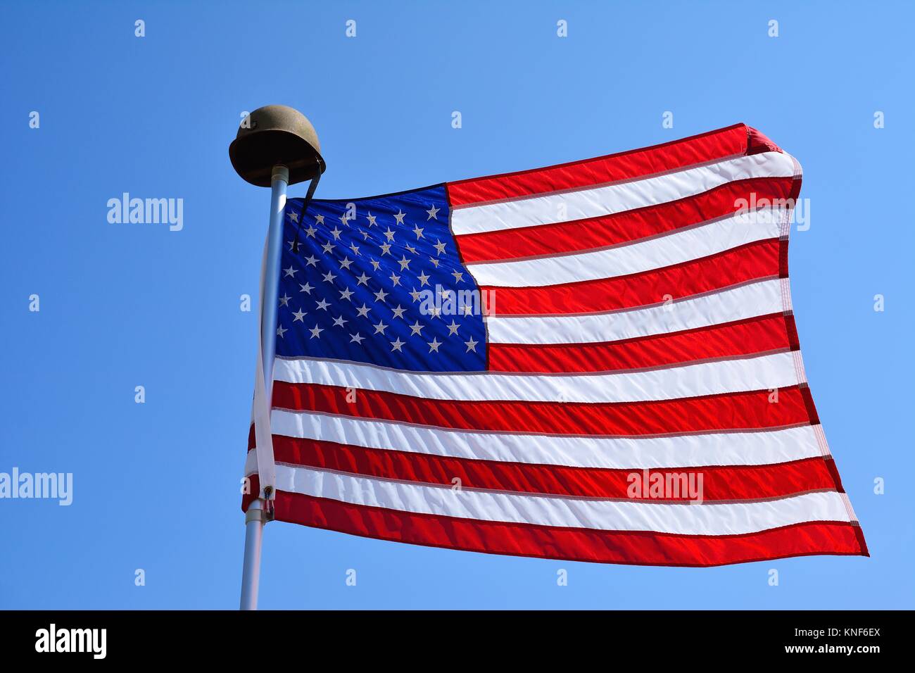 United States flag waving with a military helmet on the mast Stock ...