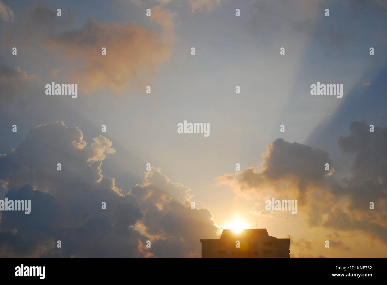 Sun rays bursting out from a building top, symbolizing concepts such as ...