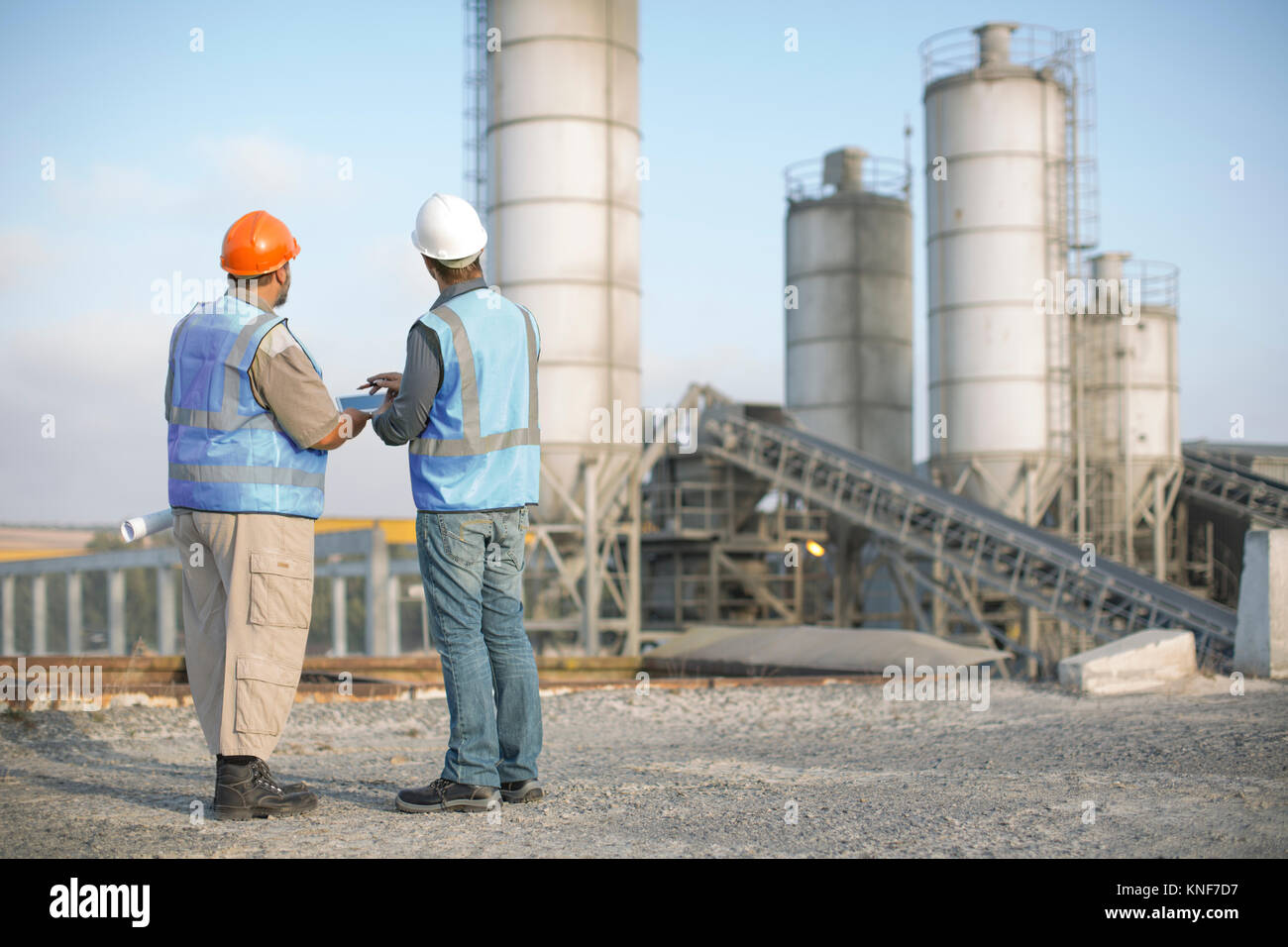 Two quarry workers in discussion, at quarry, rear view Stock Photo - Alamy
