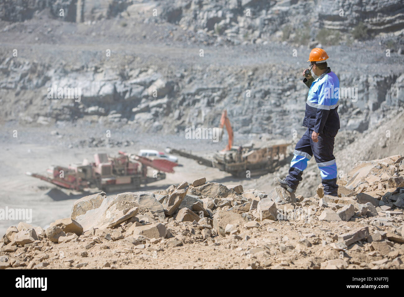 Quarry worker in quarry, talking into walkie talkie Stock Photo - Alamy