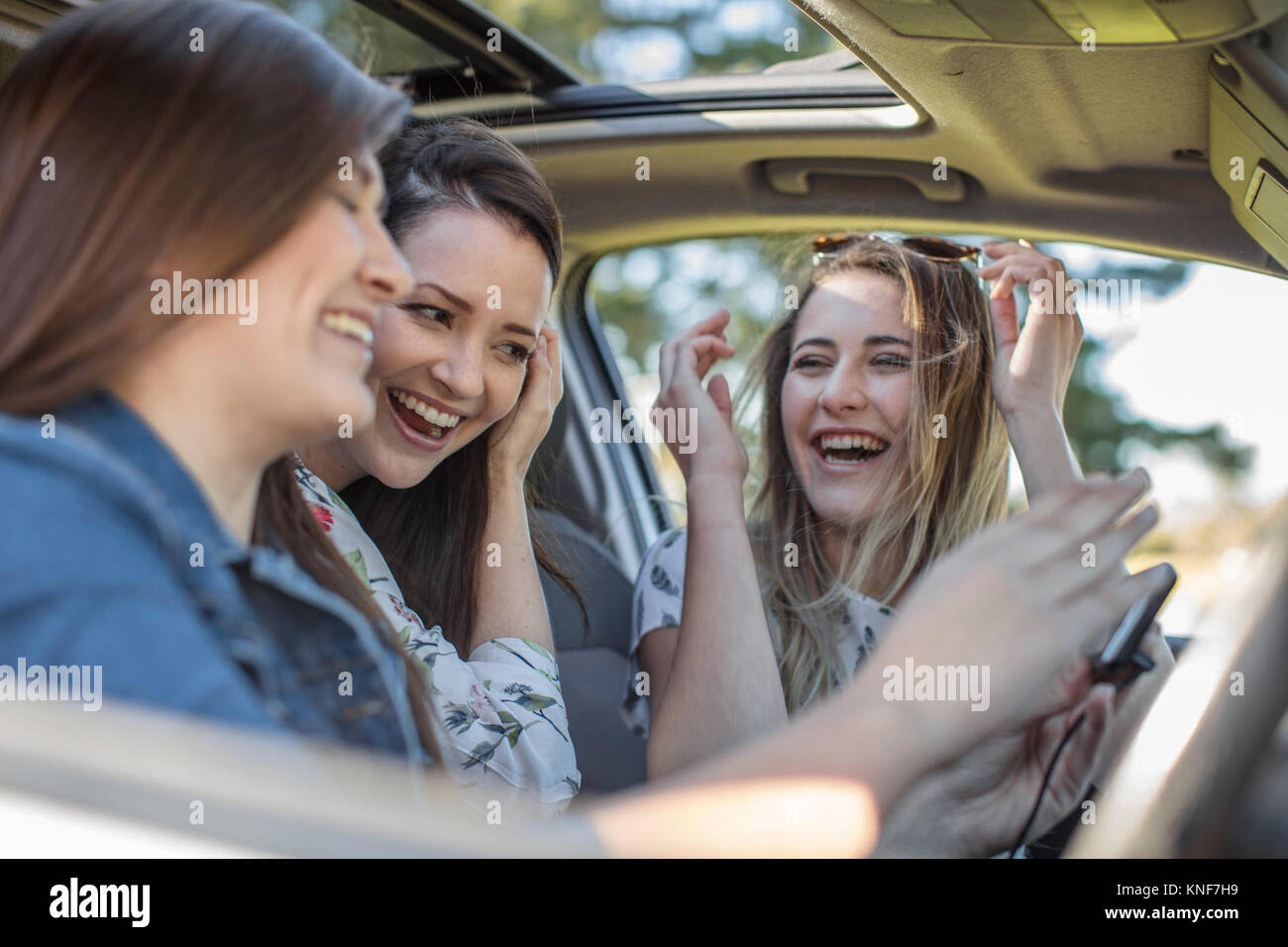 Three young women in car, laughing Stock Photo - Alamy