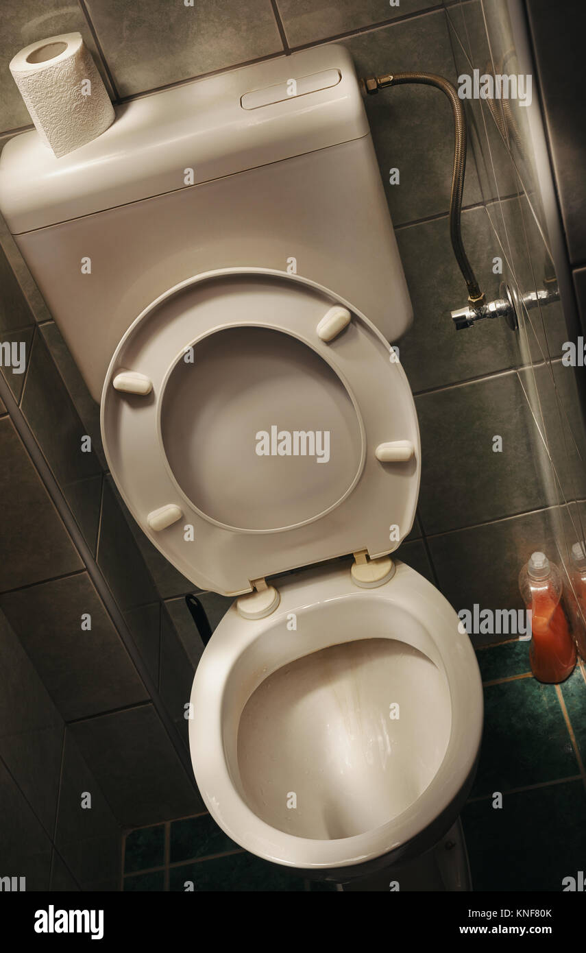 Old used toilet with toilet paper on top, accentuated objects with ...