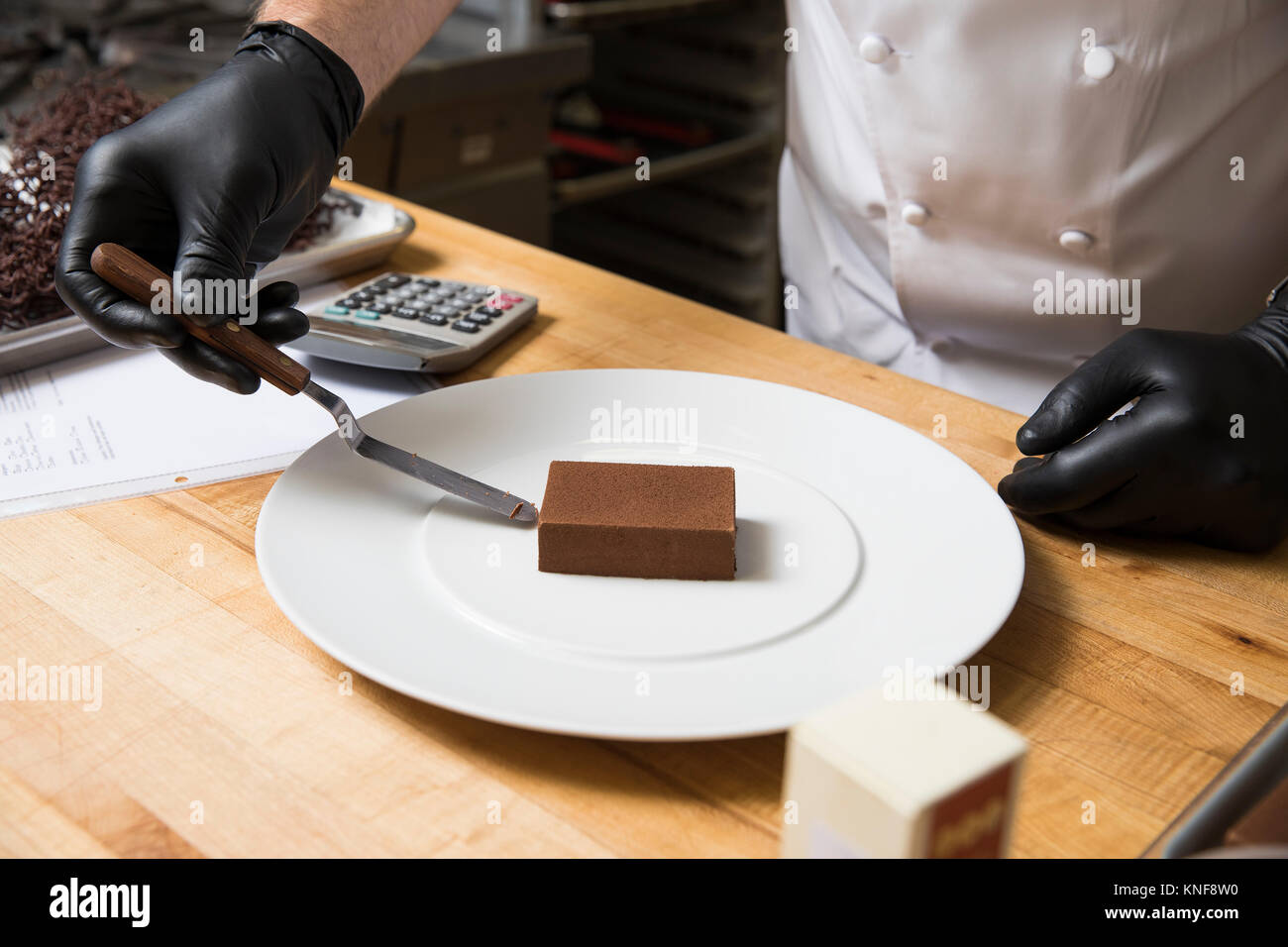 Cropped view of chef placing cake on plate Stock Photo - Alamy