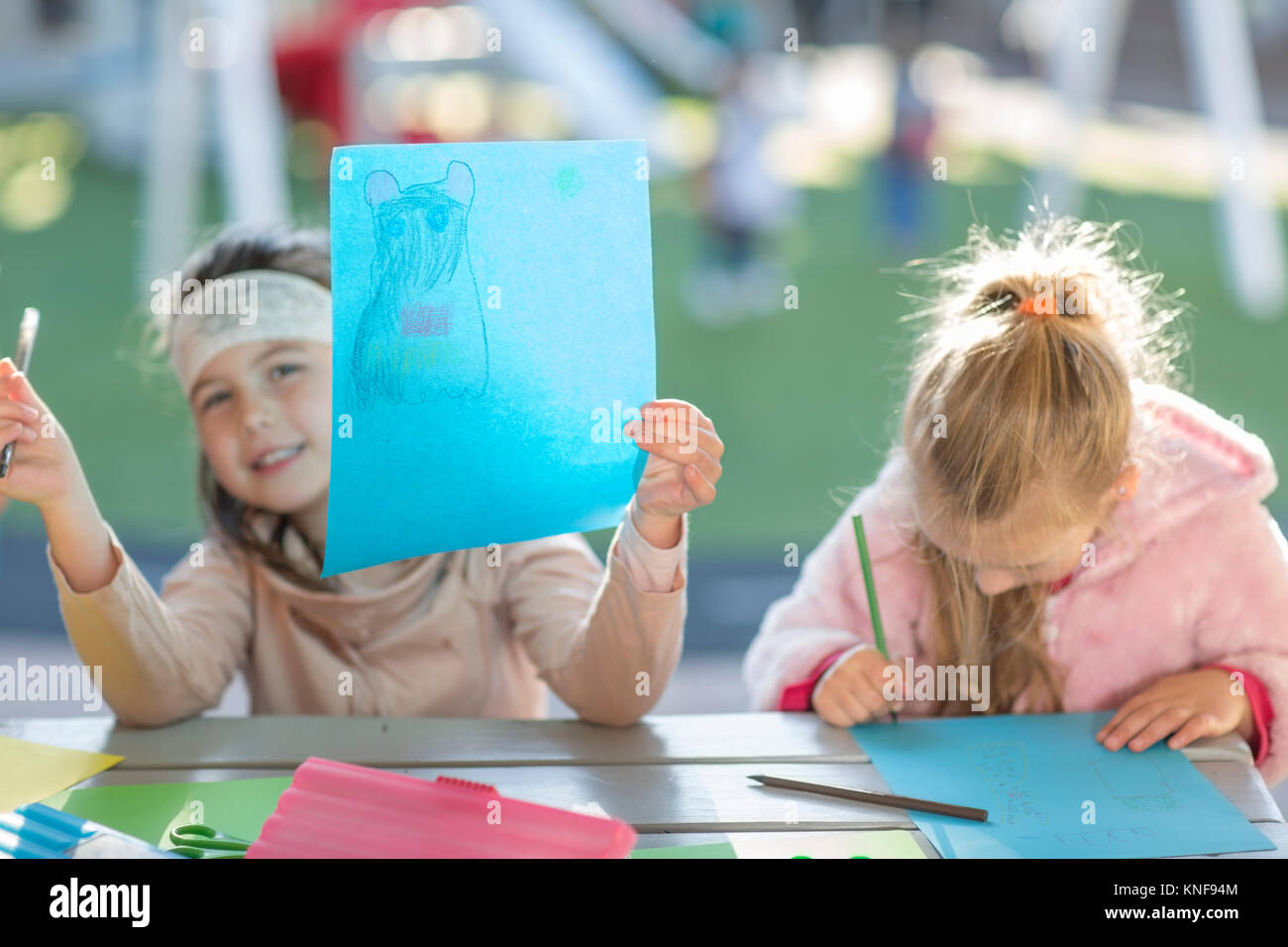 Two young girls, outdoors, drawing, young girl holding up artwork Stock ...