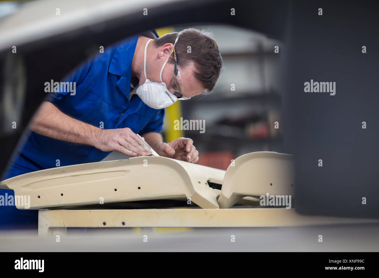 Car mechanic sanding car door in repair garage Stock Photo - Alamy