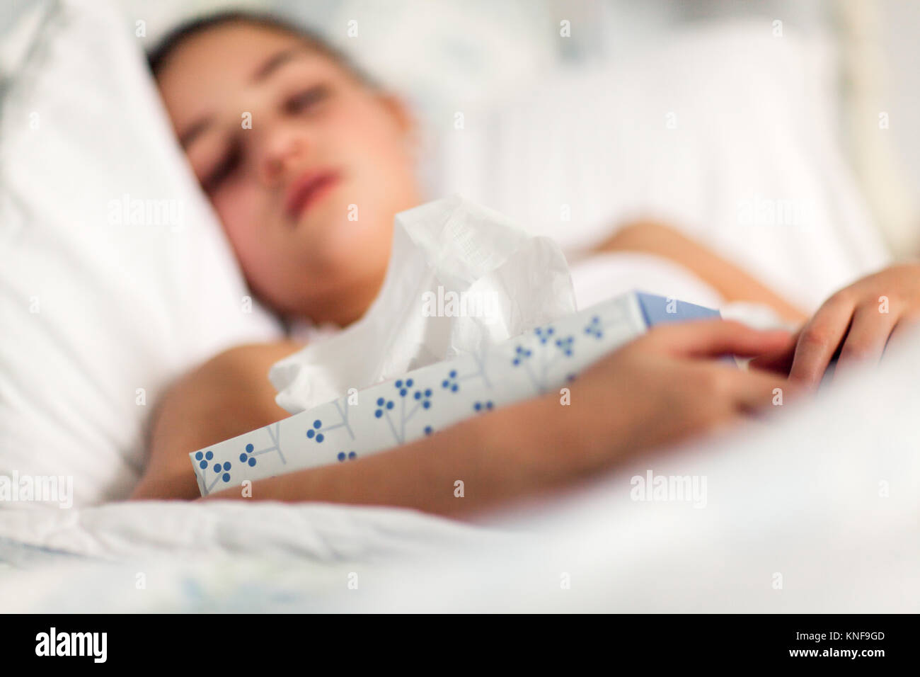 Girl in bed holding box of tissues Stock Photo - Alamy