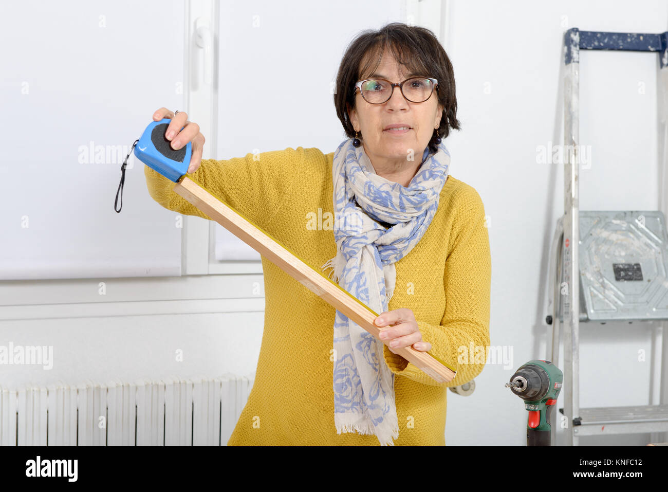 mature woman measuring a plank of wood Stock Photo - Alamy
