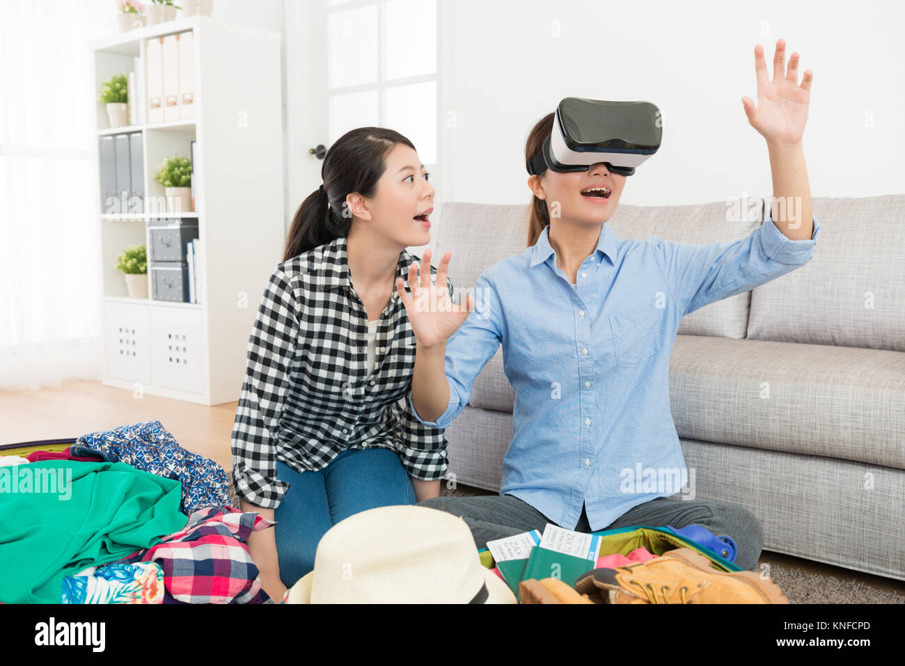 young beautiful women packing luggage suitcase at home and wearing VR ...