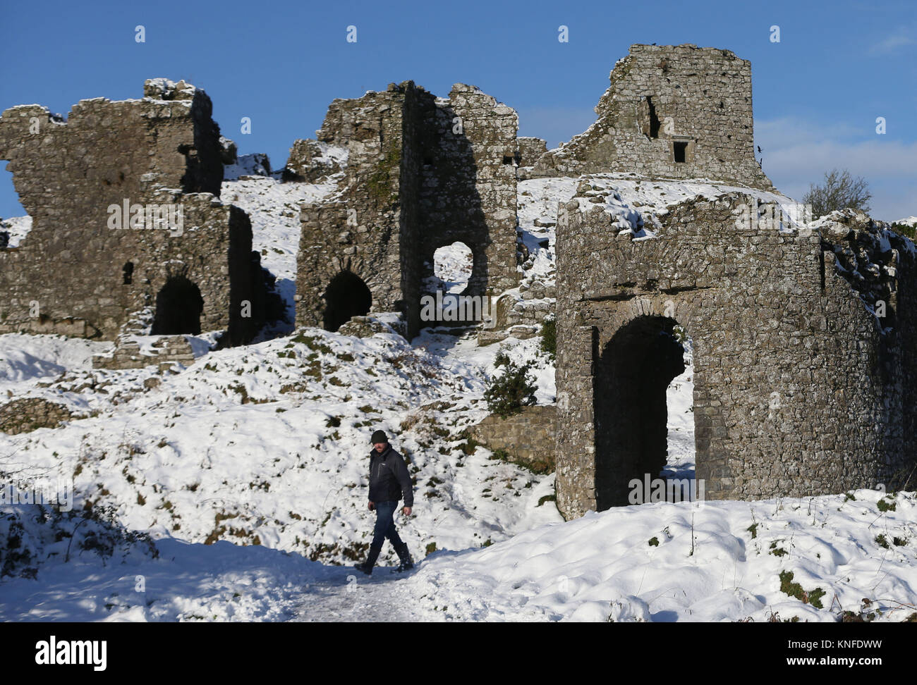 A walker visits the snow-covered ruins of Dunamase castle on the Rock ...