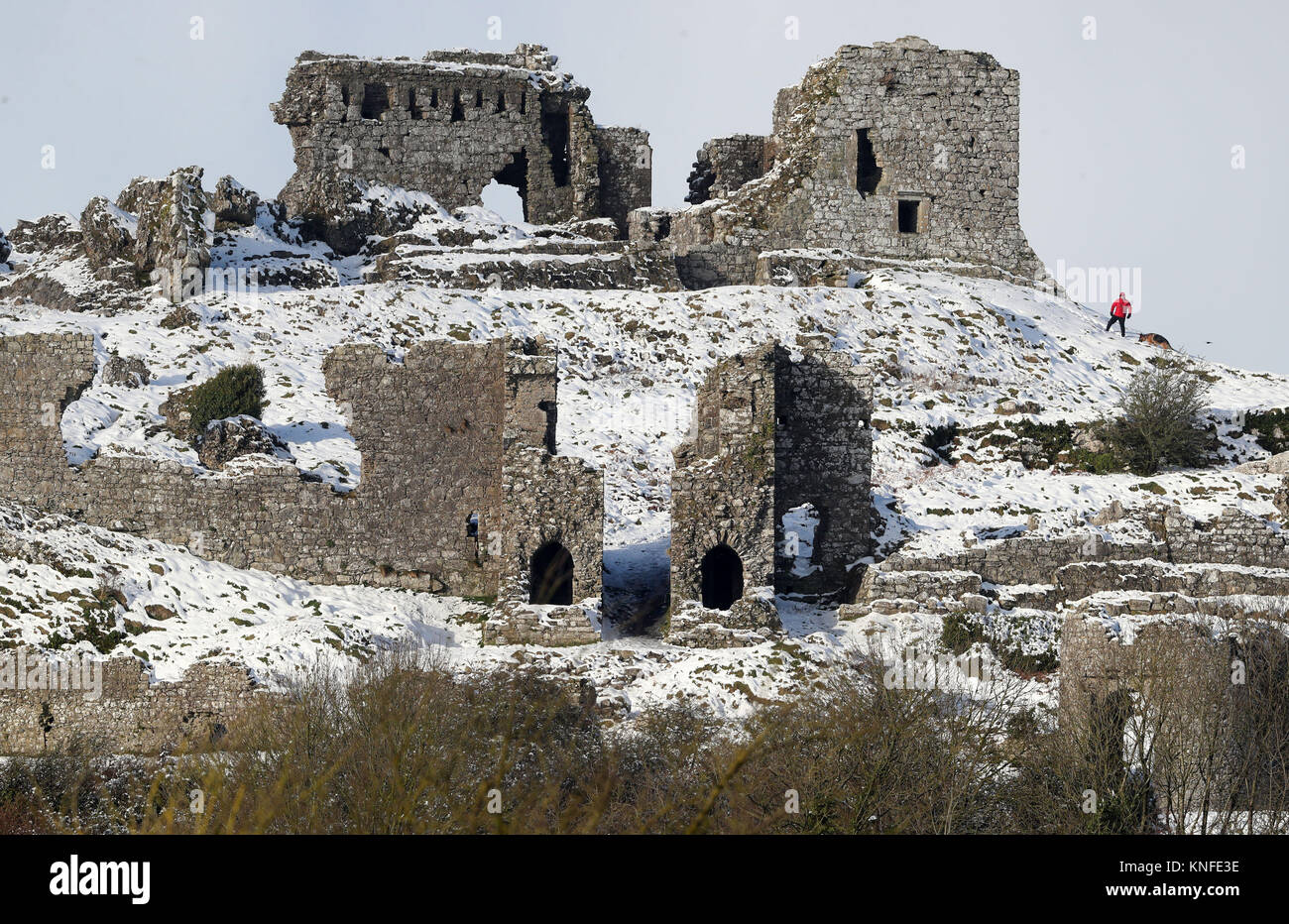 A walker visits the snow-covered ruins of Dunamase castle on the Rock ...