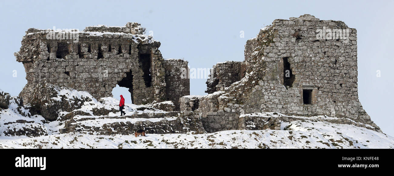 A walker visits the snow-covered ruins of Dunamase castle on the Rock ...