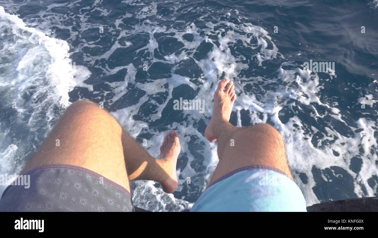 Feet of man on a boat above ocean Stock Photo - Alamy