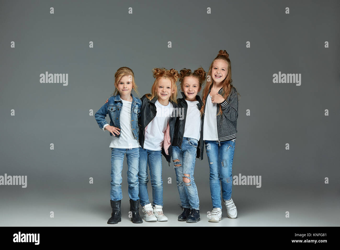 Young girls posing together on gray studio background Stock Photo - Alamy