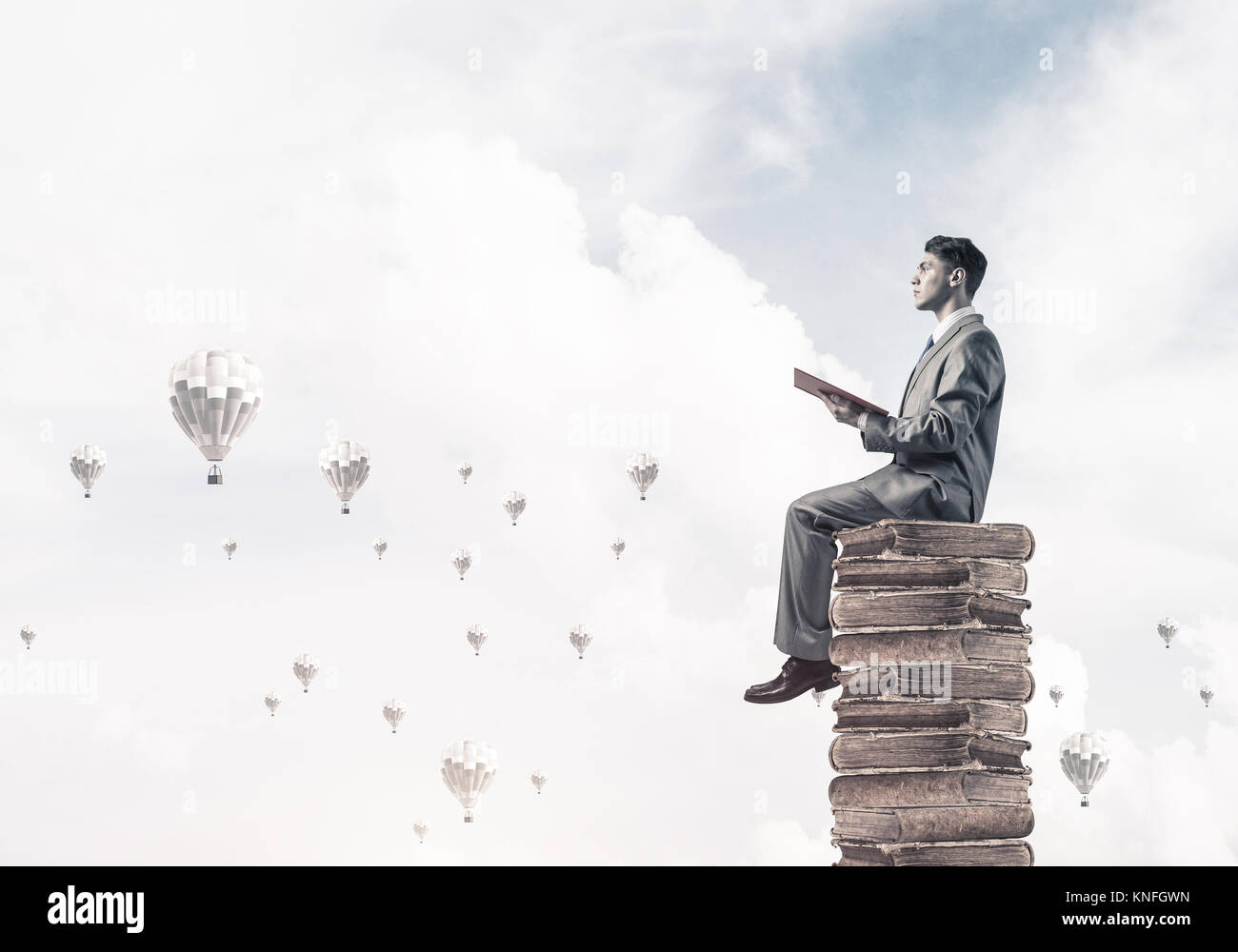 Man student reading book and aerostats flying around in air Stock Photo ...