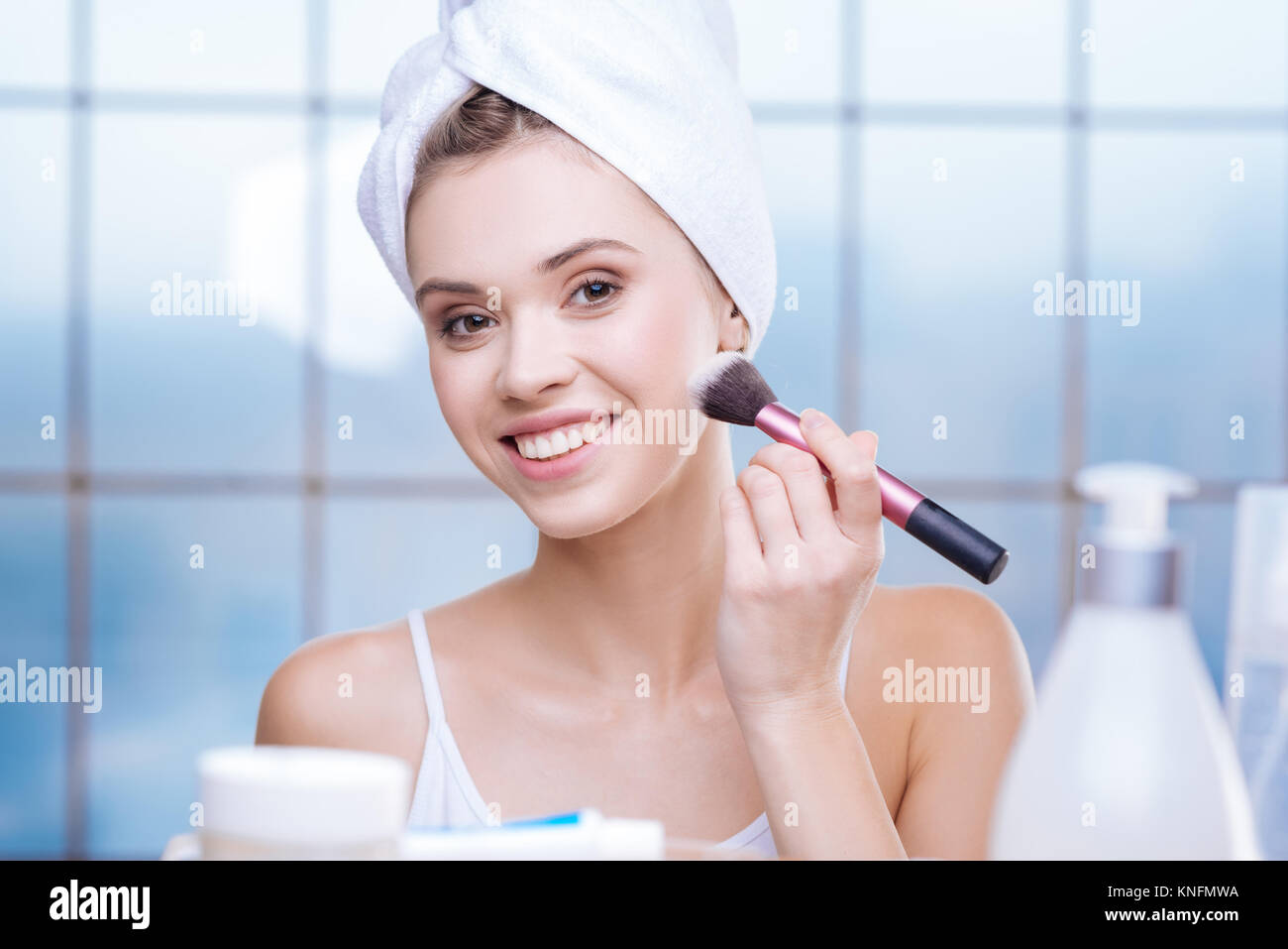 Joyful woman applying powder to her skin Stock Photo - Alamy