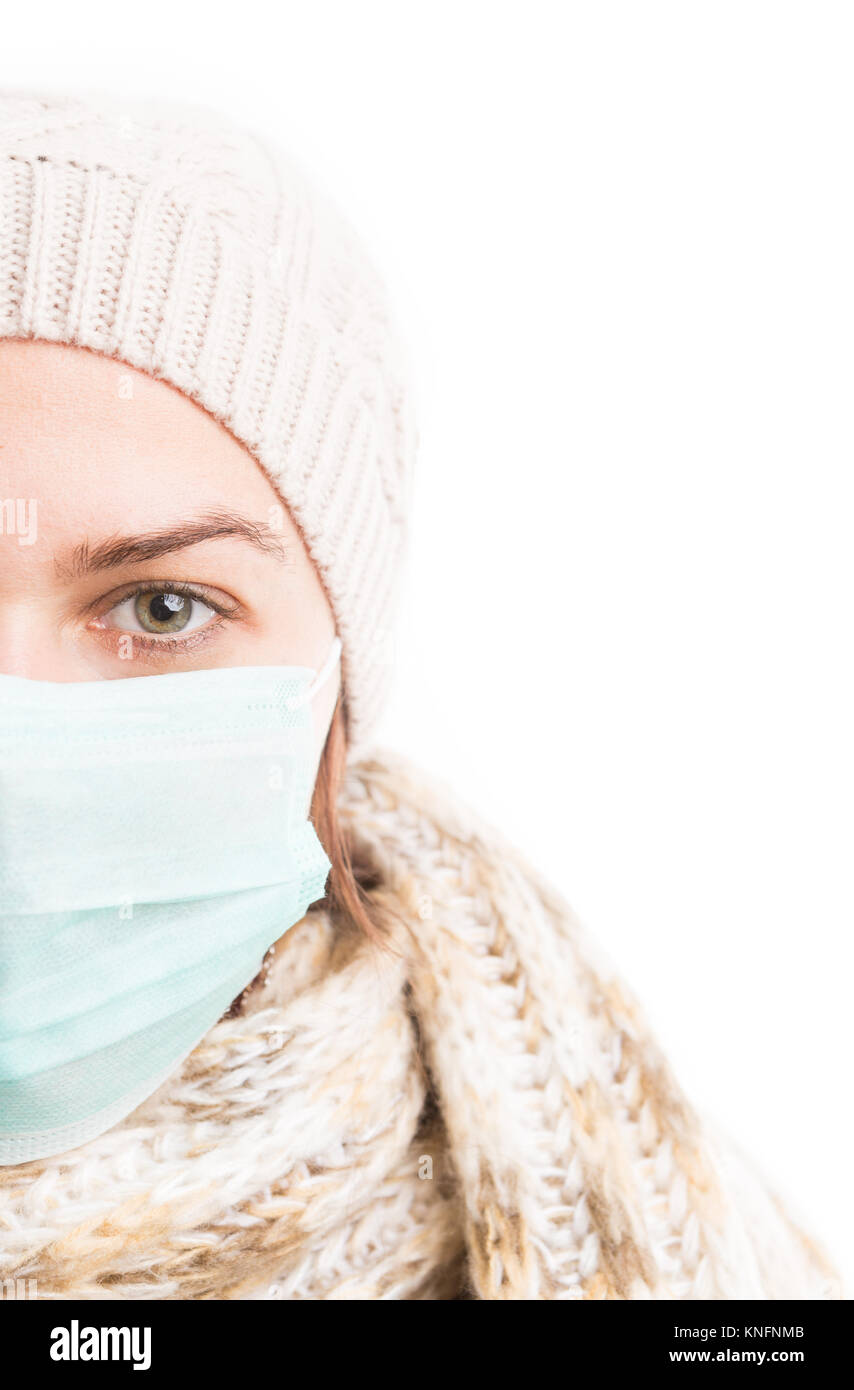 Half face of cold woman wearing medical mask and warm clothes as ...