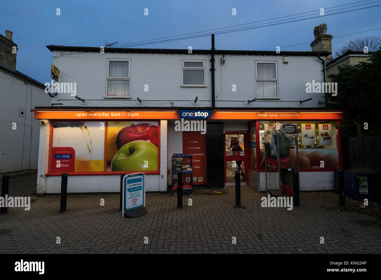 One Stop shop lit up on High street Milton at dusk Stock Photo - Alamy
