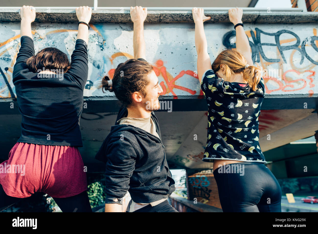 young man and women doing parkour outdoor - stunt, acrobat, athlete ...