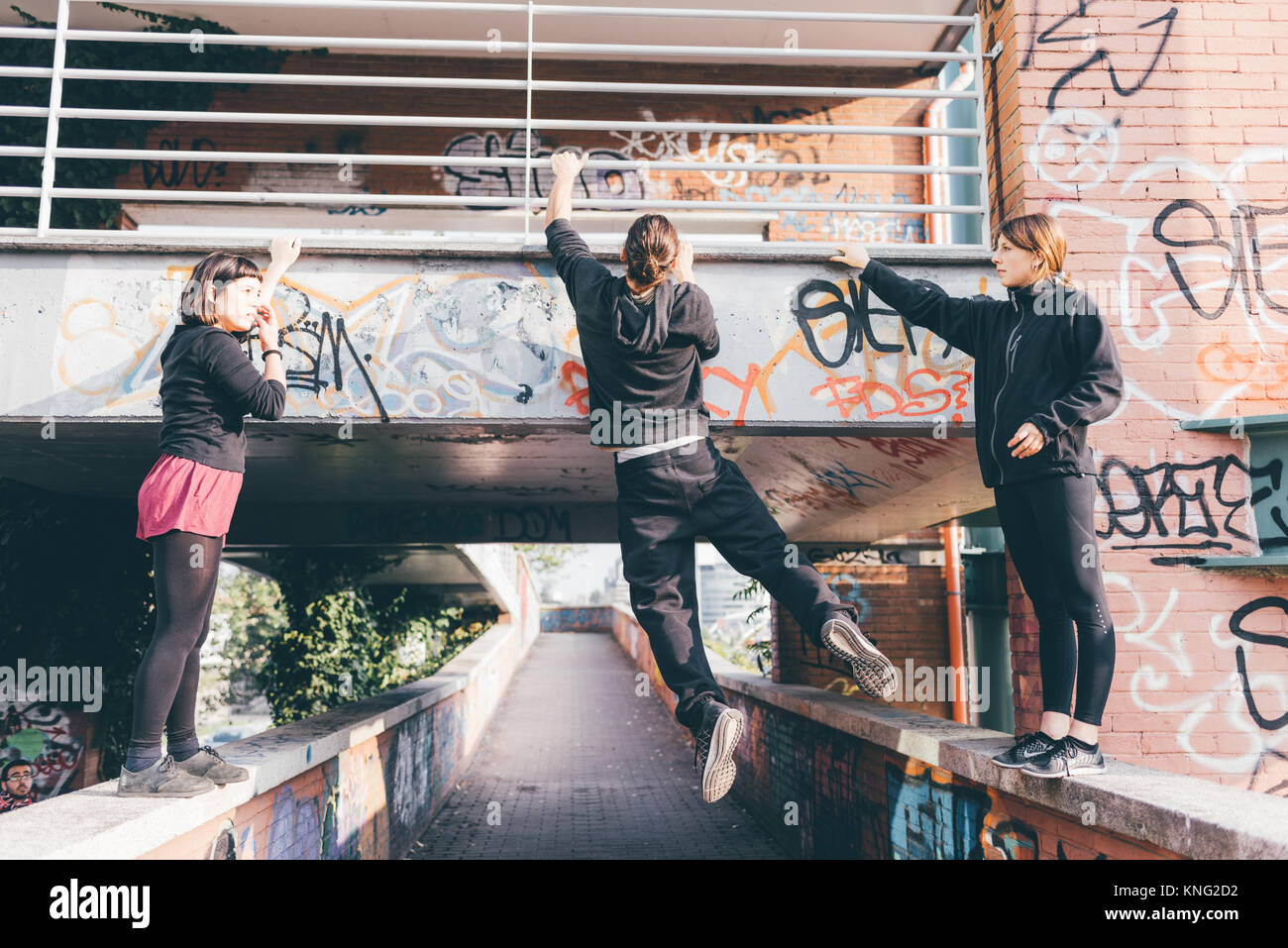young man and women doing parkour outdoor - stunt, acrobat, athlete ...