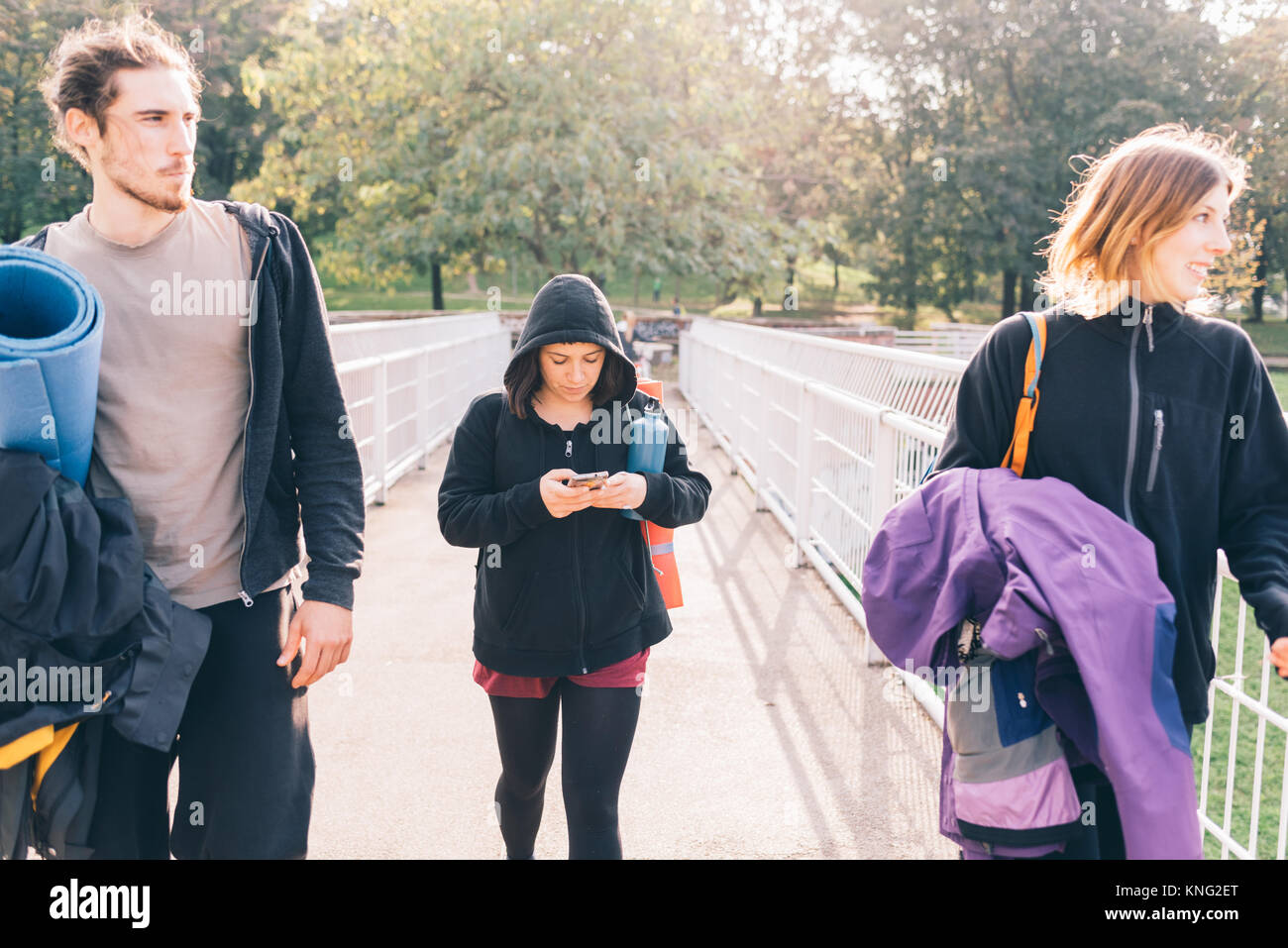 Three young beautiful caucasian sportive friends walking outdoor in the ...