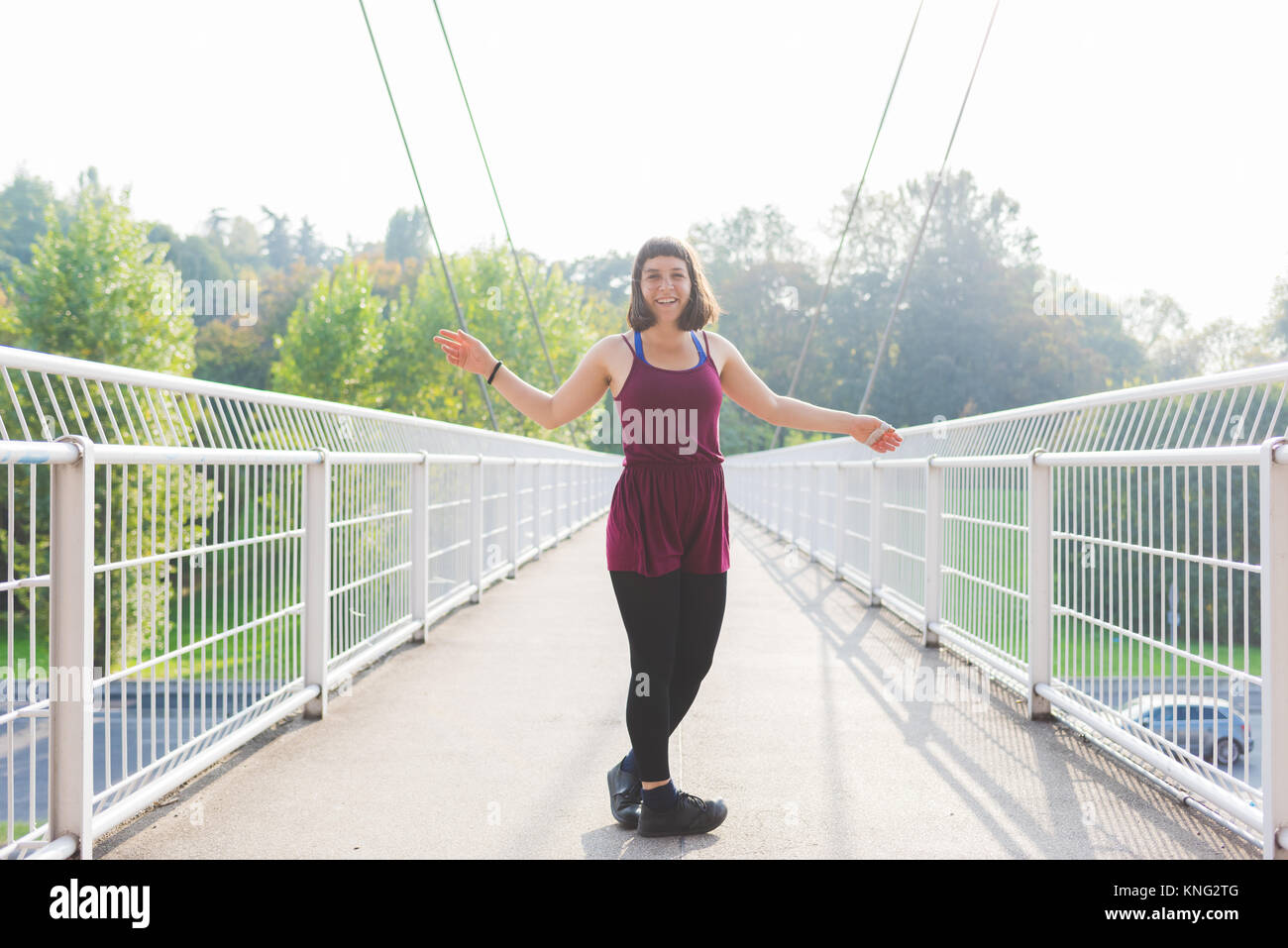 young woman standing bridge looking camera smiling - happiness ...