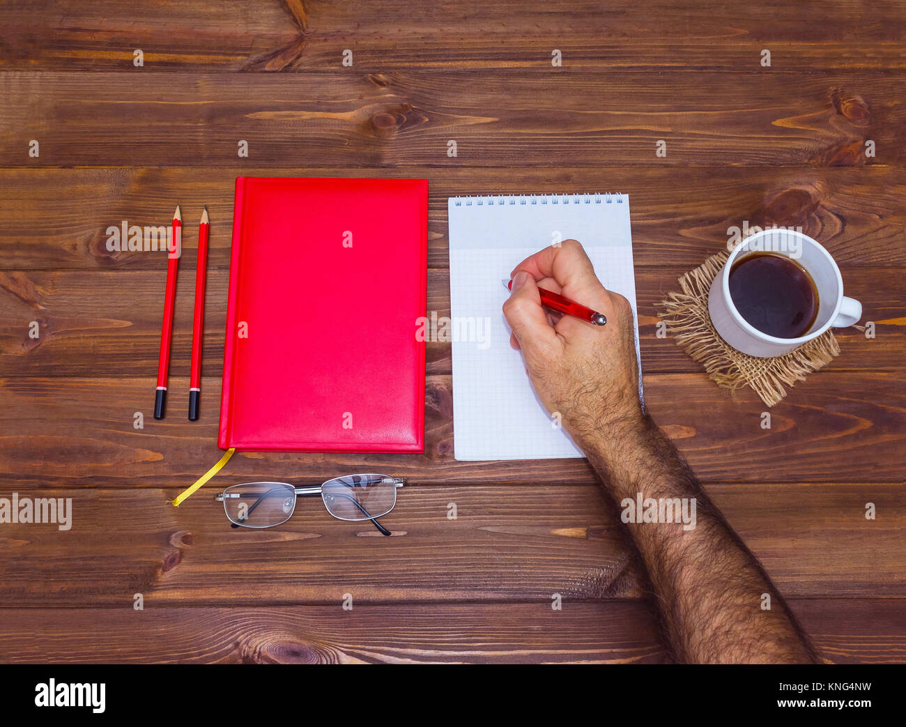 The male hand, calendar, note book and pencil with cup coffee on wooden ...
