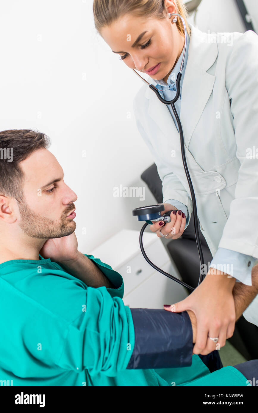 Female doctor checking blood pressure of a patient at clinic Stock ...