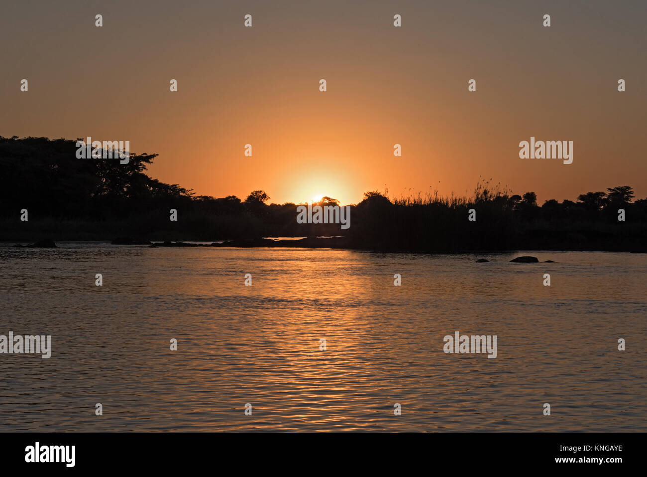 sunset on the okavango river in namibia Stock Photo - Alamy