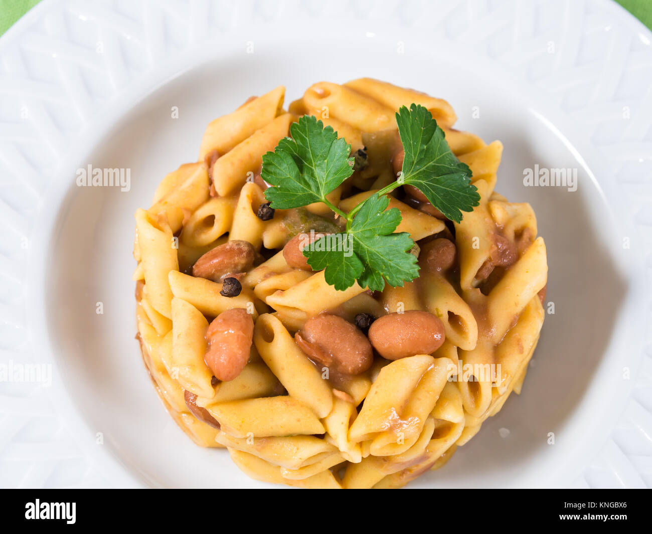 Served traditional Italian penne pasta with kidney beans on white plate ...
