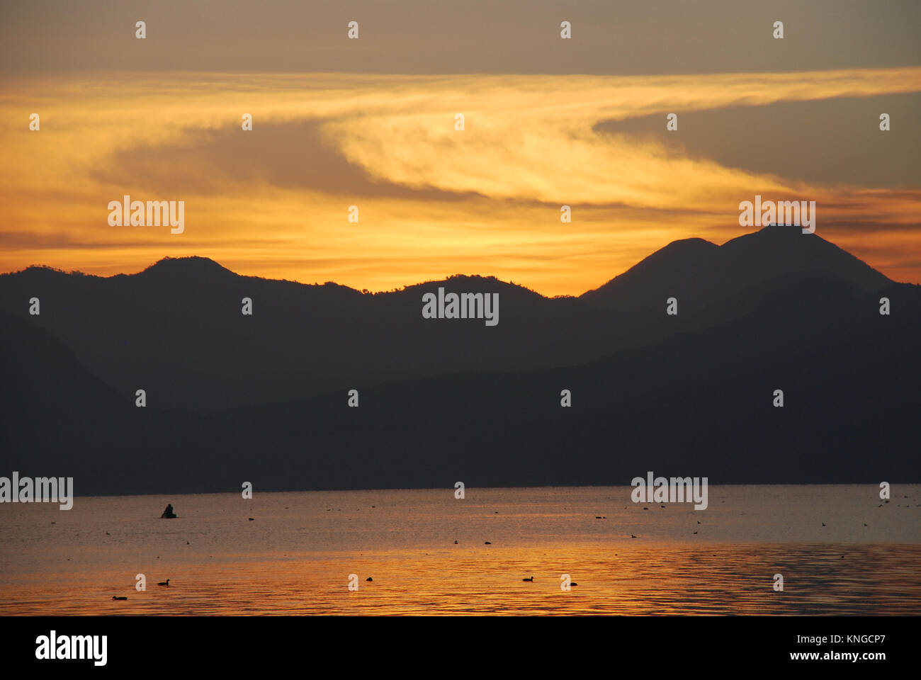 Sunrise at Lake Atitlan in Guatemala which is surrounded by high cliffs ...