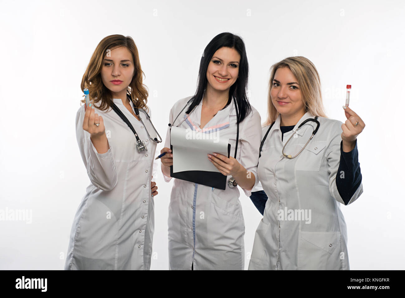 Three female doctors looking at the test results. On a white background ...